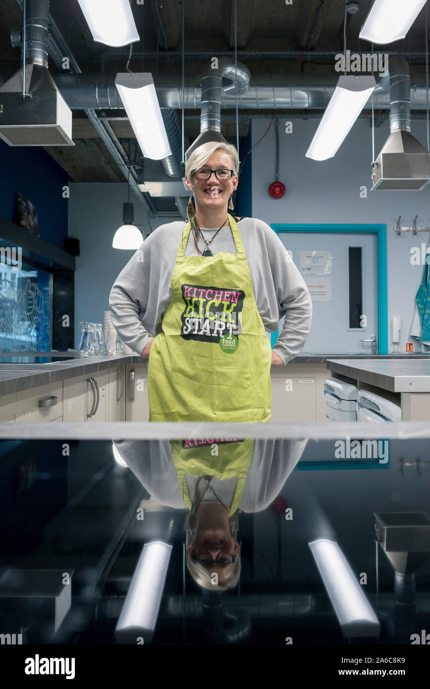 A chef stands in an industrial clean kitchen with an apron on Stock ...