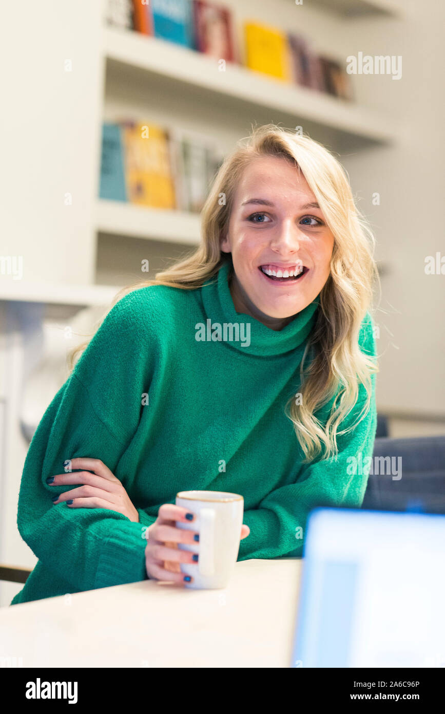 A female office worker poses for an informal profile photo of them ...