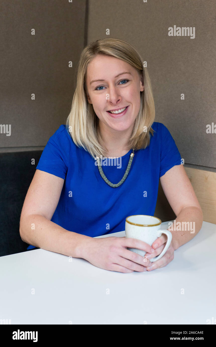A female office worker poses for an informal profile photo of them ...
