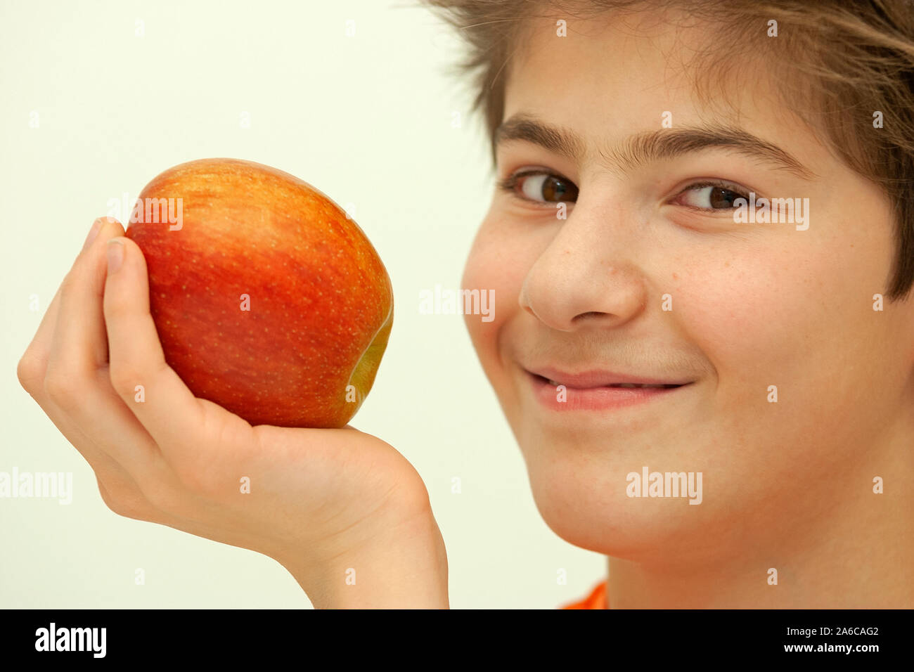 Portrait of a young boy holding a red apple in his hand Stock Photo - Alamy