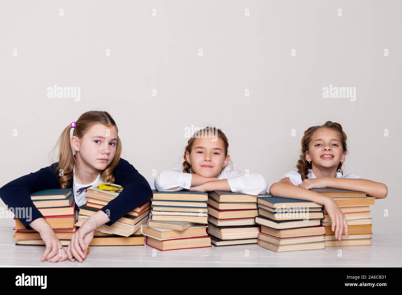 three girls in class at school with a lot of books Stock Photo - Alamy
