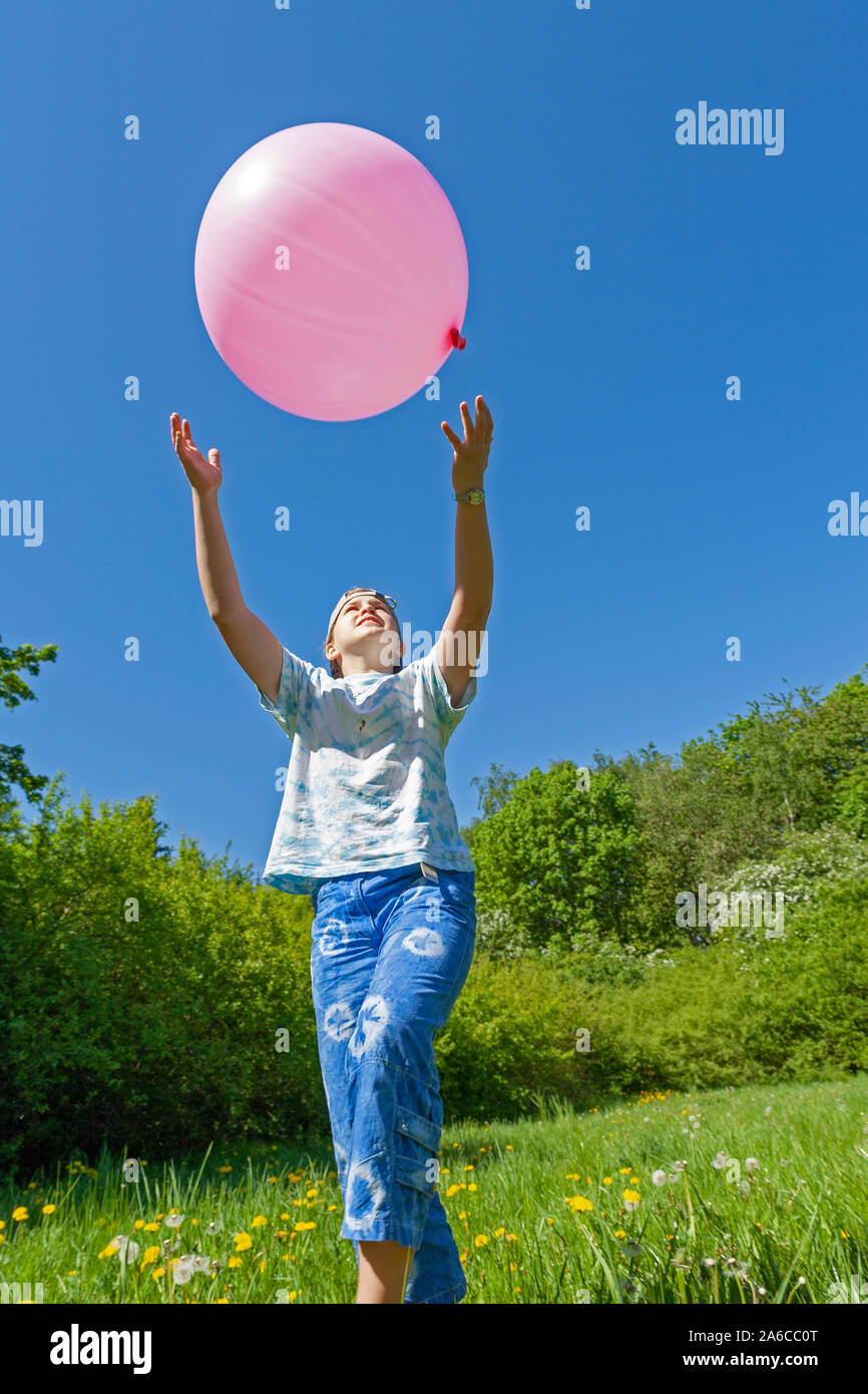 A young girl trying to catch a big balloon Stock Photo - Alamy