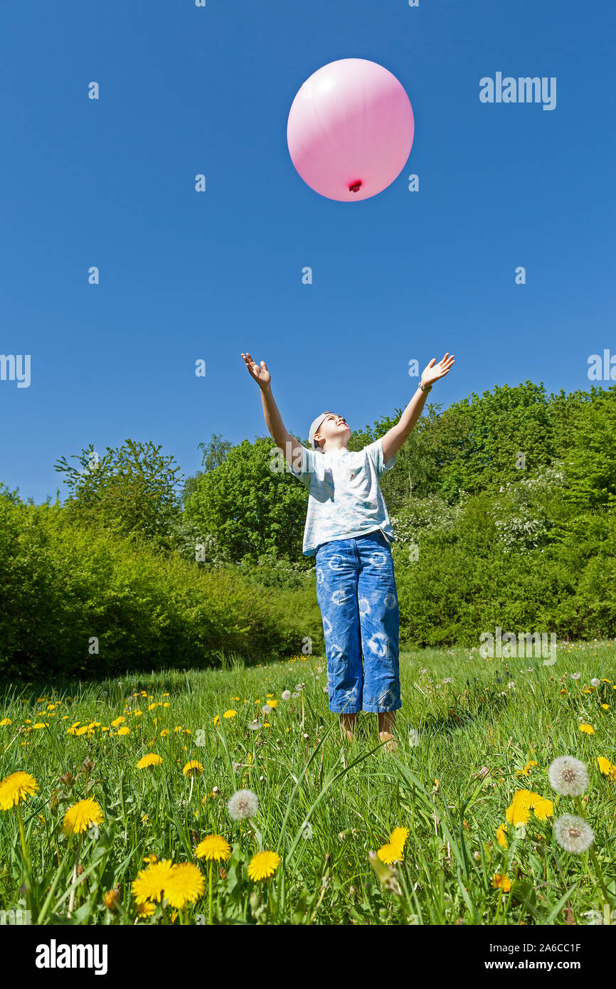 A young girl trying to catch a big balloon Stock Photo - Alamy