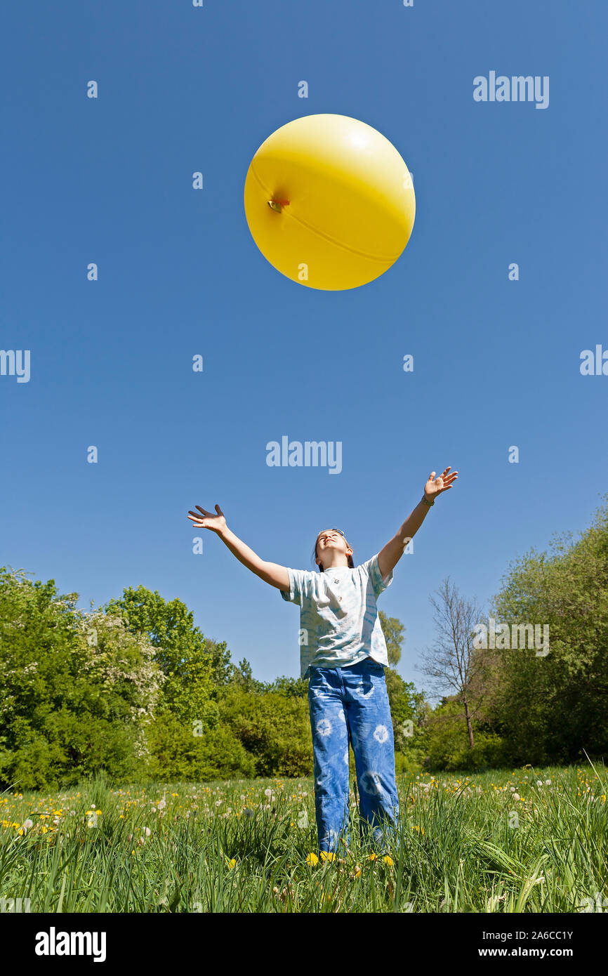 A young girl trying to catch a big balloon Stock Photo - Alamy