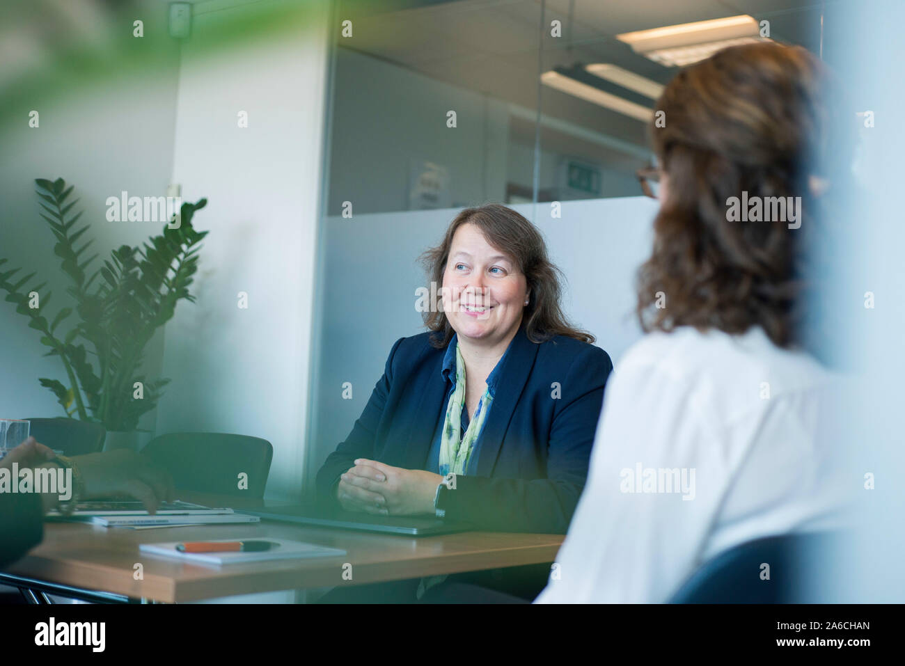 Women sit around a meeting table holding a productive meeting Stock ...