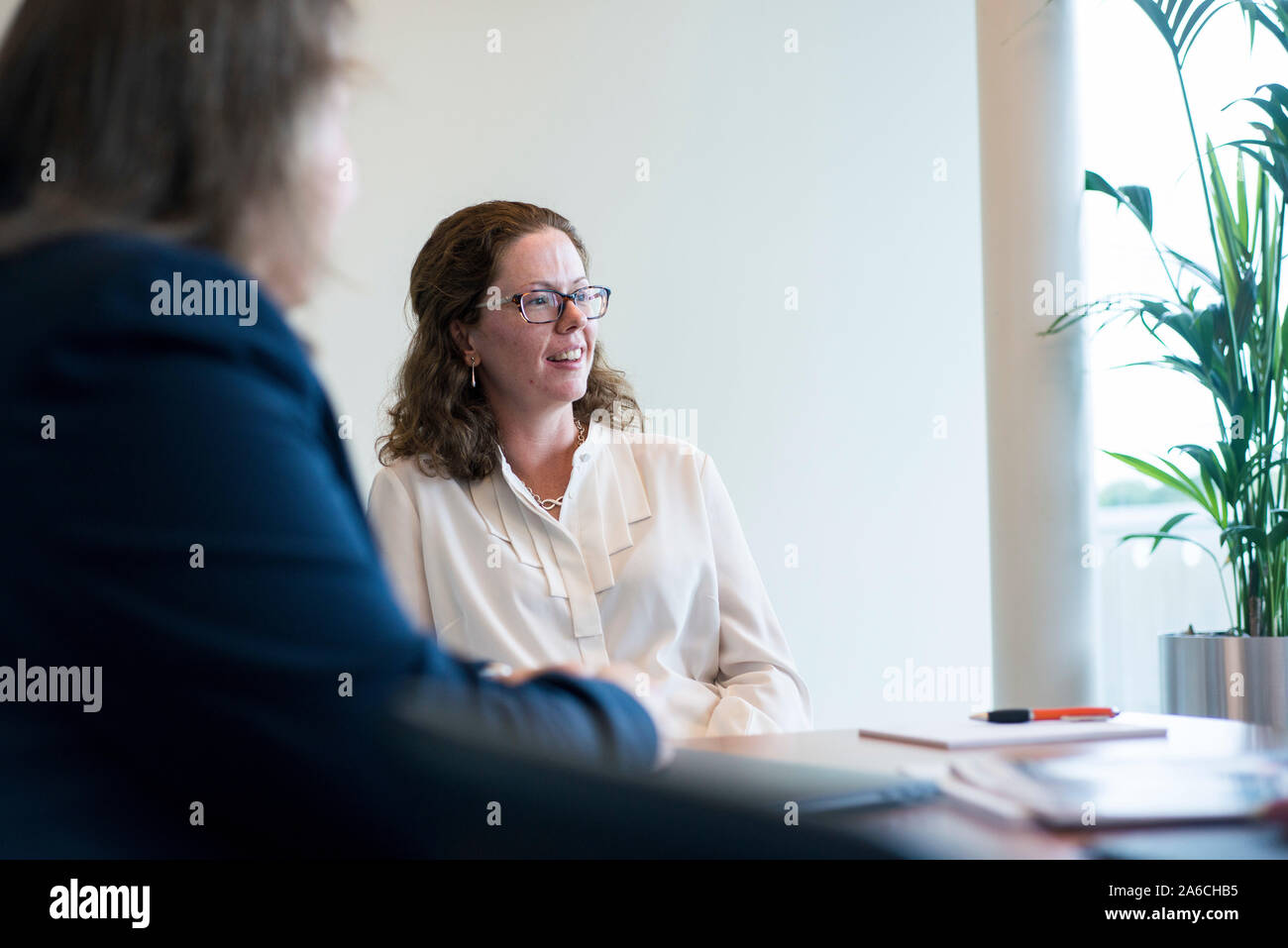 Women sit around a meeting table holding a productive meeting Stock ...