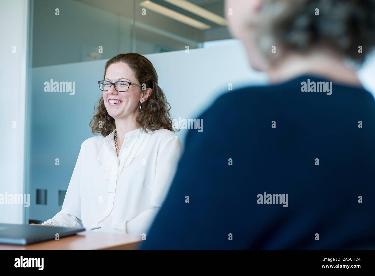 Women sit around a meeting table holding a productive meeting Stock ...