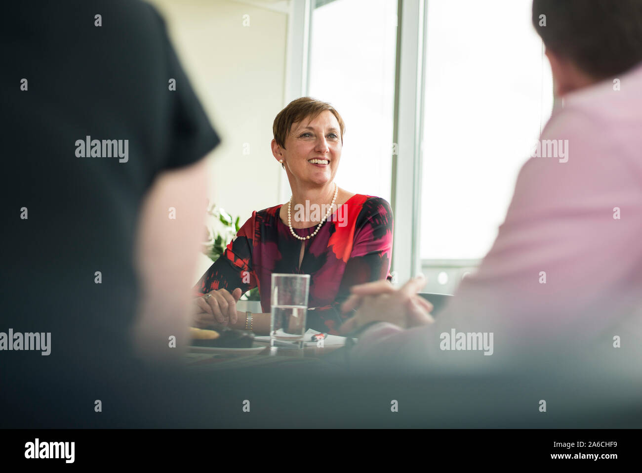 Women sit around a meeting table holding a productive meeting Stock ...