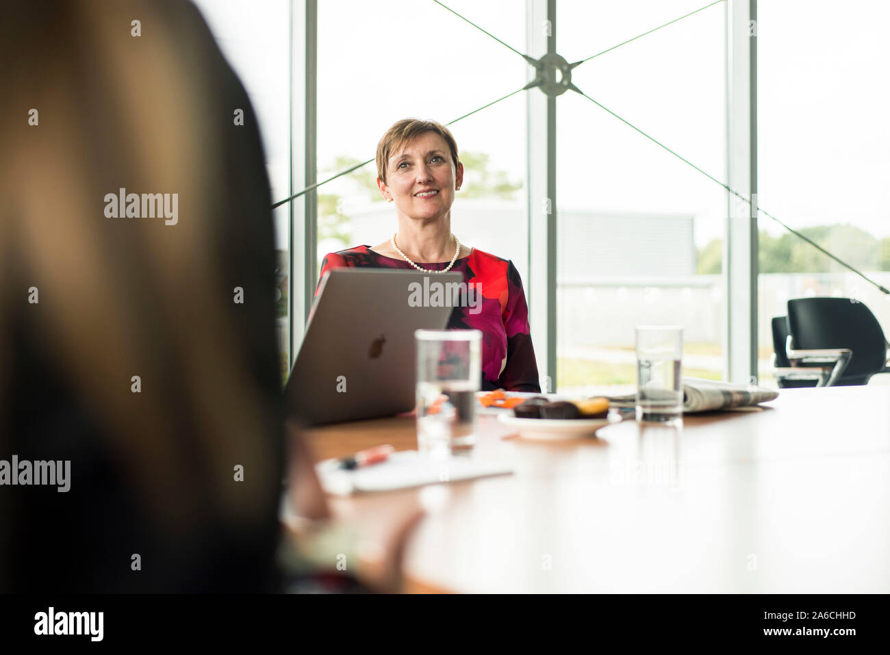 Women sit around a meeting table holding a productive meeting Stock ...