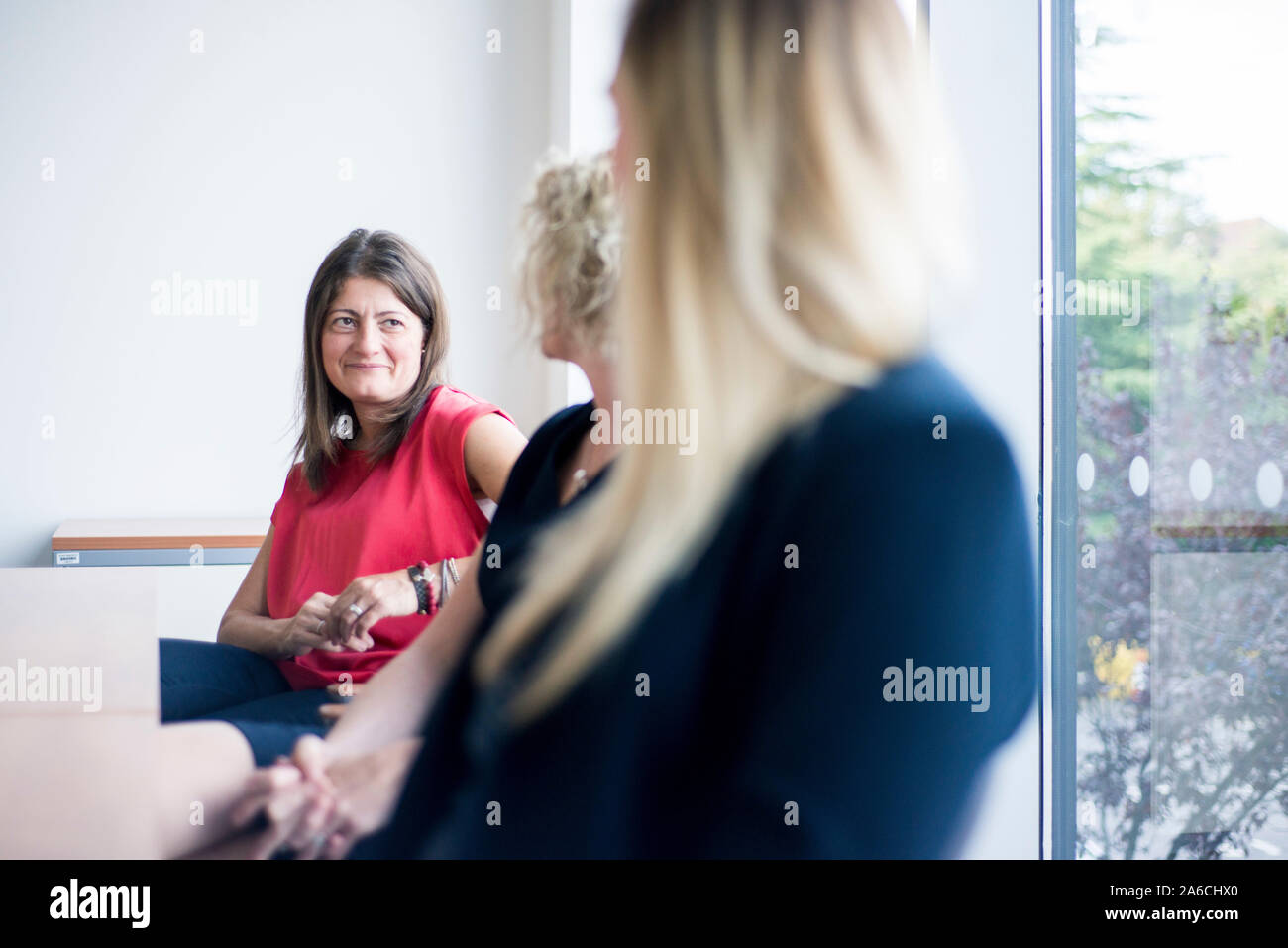 Women sit around a meeting table holding a productive meeting Stock ...