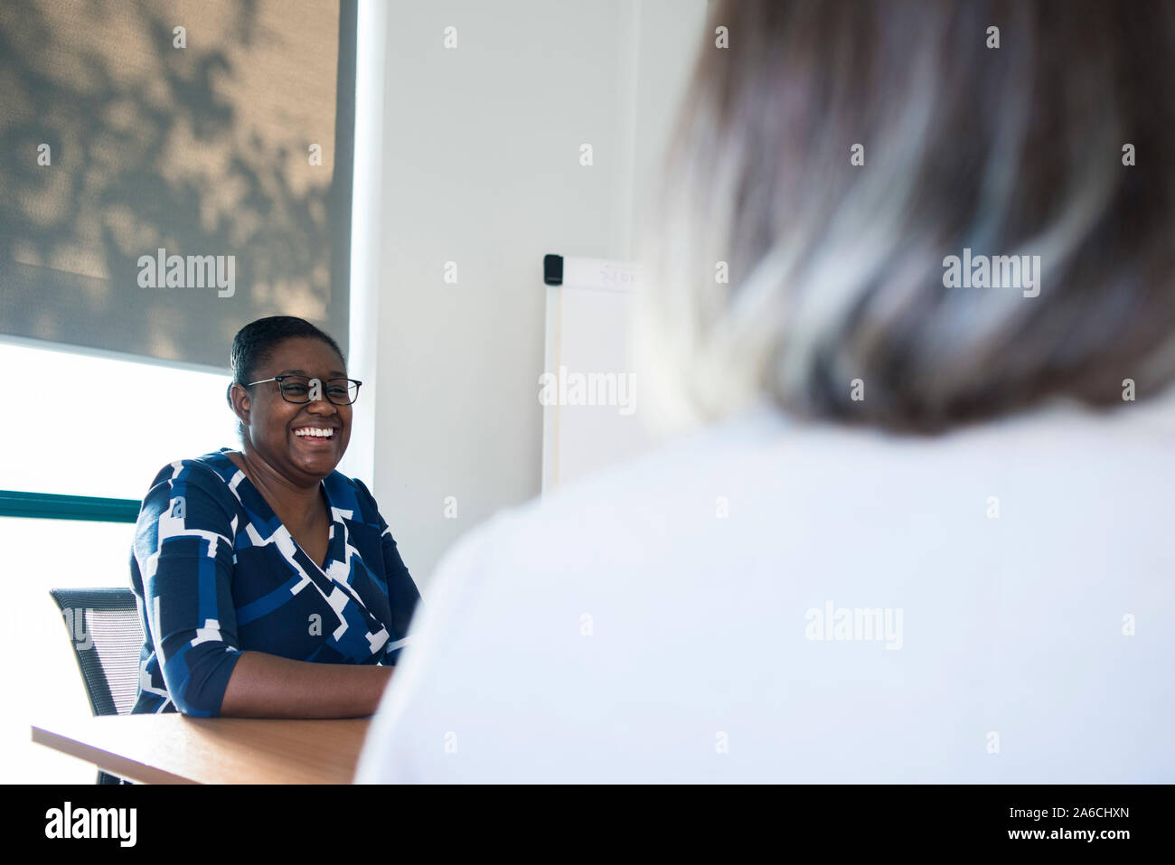 Women sit around a meeting table holding a productive meeting Stock ...