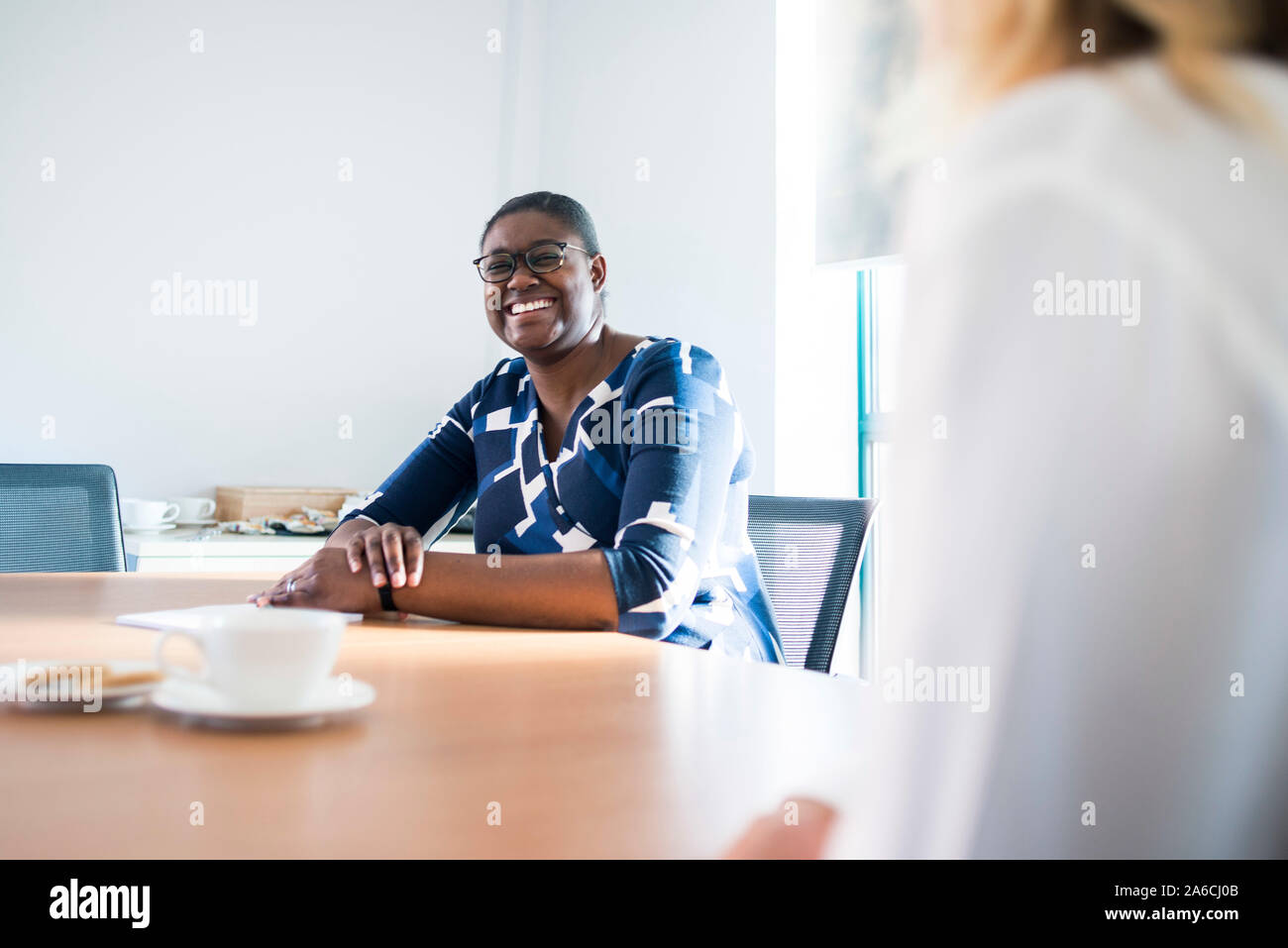 Women sit around a meeting table holding a productive meeting Stock ...