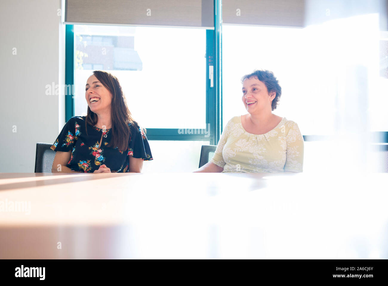 Women sit around a meeting table holding a productive meeting Stock ...