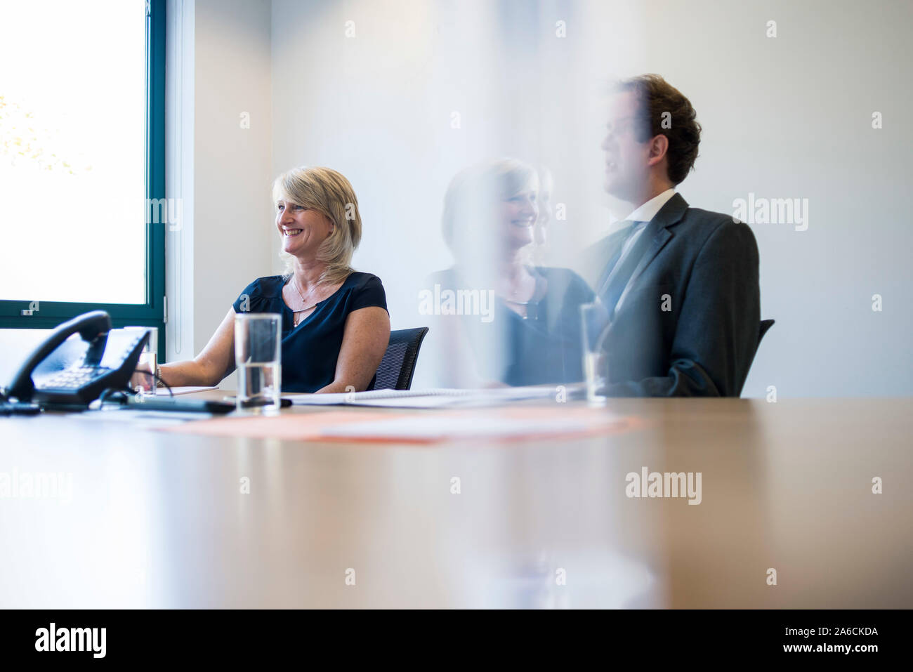 Women sit around a meeting table holding a productive meeting Stock ...
