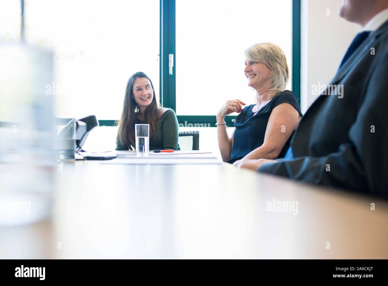 Women sit around a meeting table holding a productive meeting Stock ...