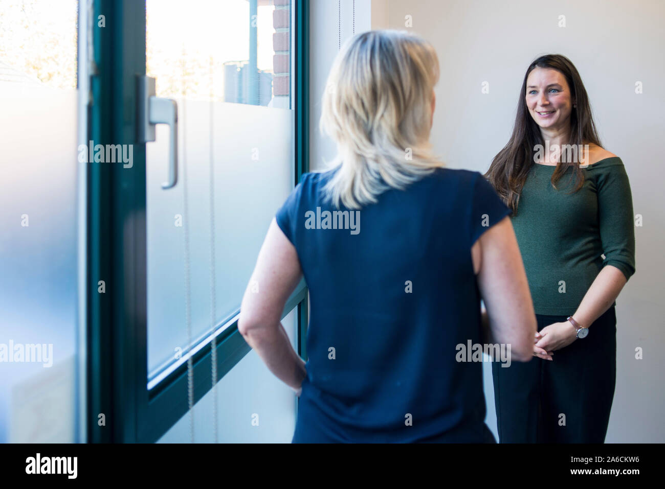 two people meet in a modern office and have an informal chat Stock ...