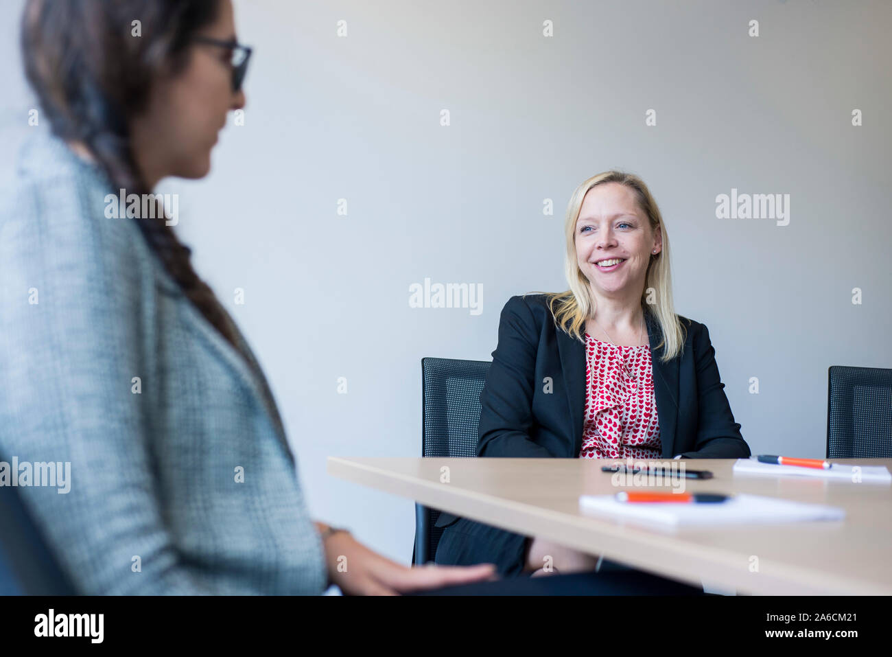 Women sit around a meeting table holding a productive meeting Stock ...