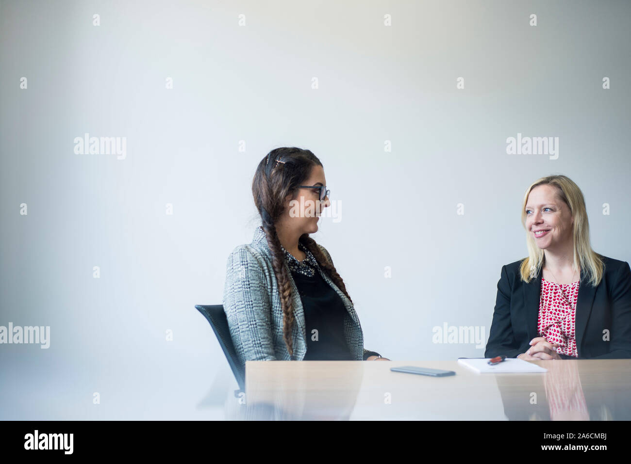 Women sit around a meeting table holding a productive meeting Stock ...
