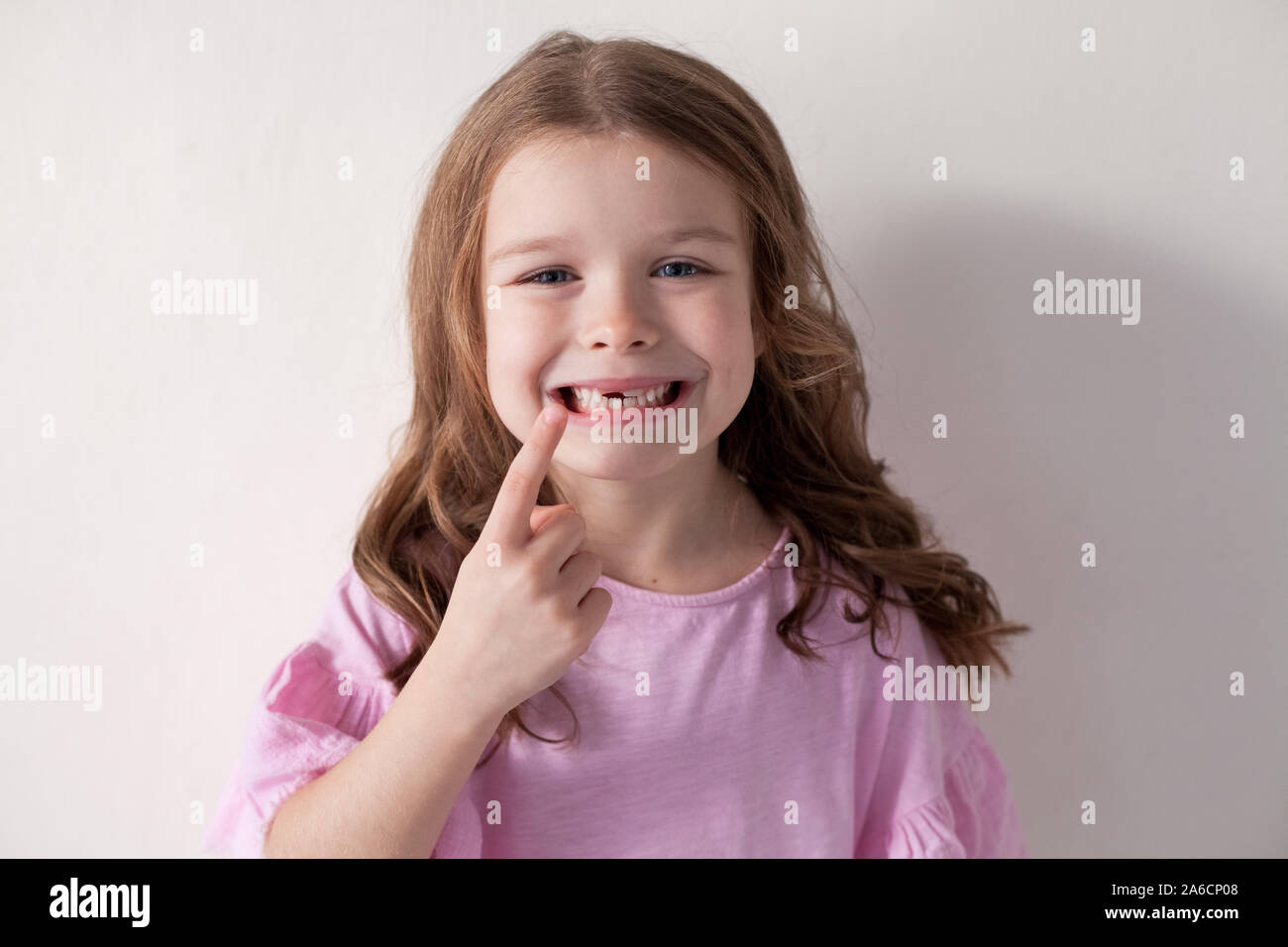 Beautiful little girl shows a fallen tooth Stock Photo - Alamy