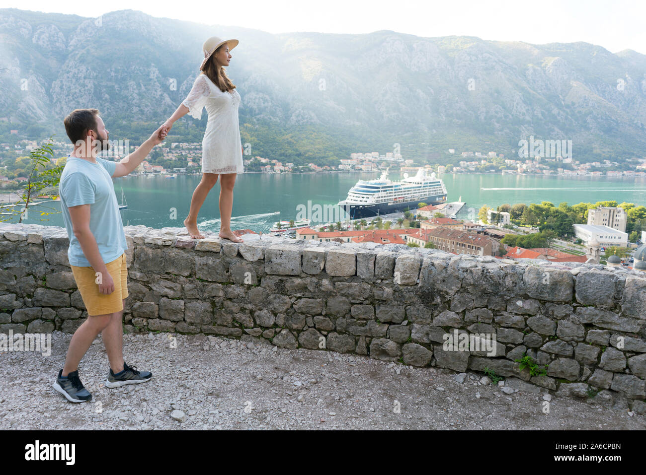 girl walking along the parapet at the fortress above Kotor, boyfriend ...