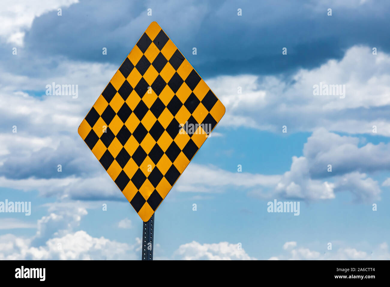 A closeup view of a checked yellow and black dead end road warning sign ...