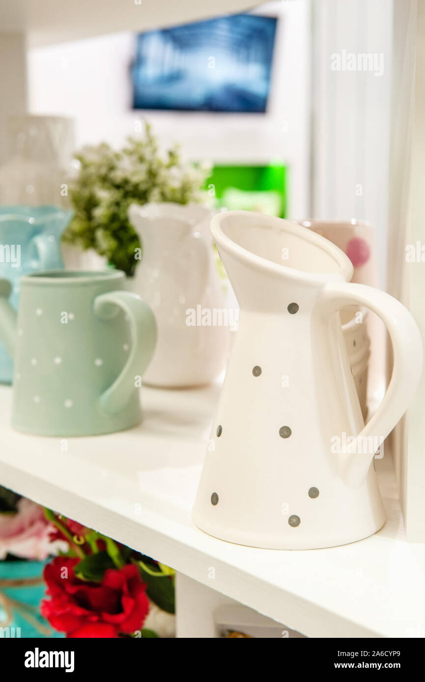 A pitcher and a set of clean dishes and home furnishings on white ...