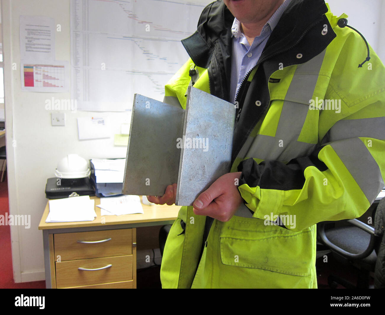 October 2013 - Construction site Engineer holding a cladding fixing ...