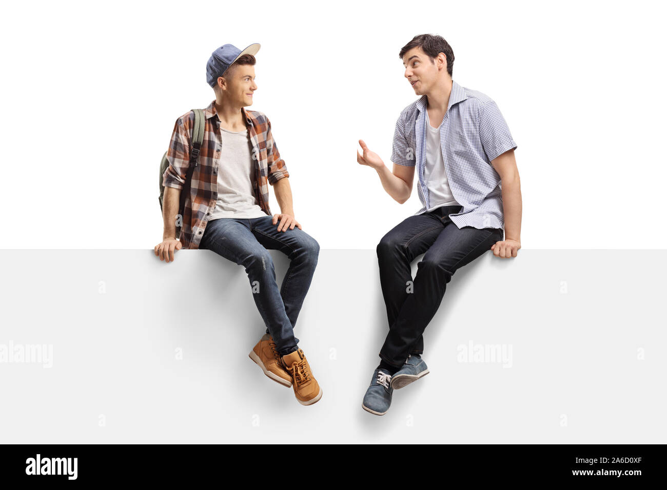 Full length shot of two young men sitting on a panel and talking ...