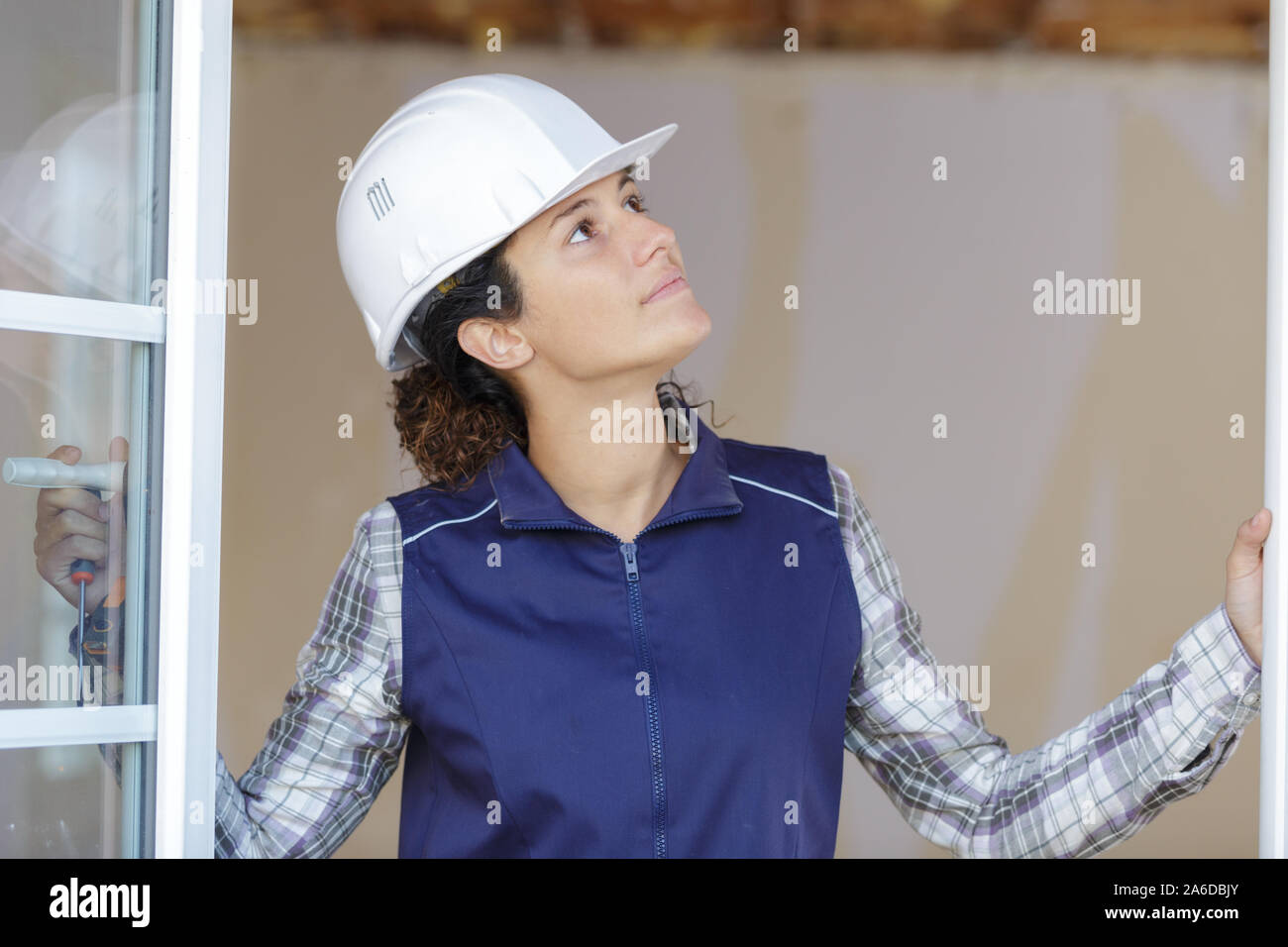 female builder inspecting pvc windows Stock Photo - Alamy