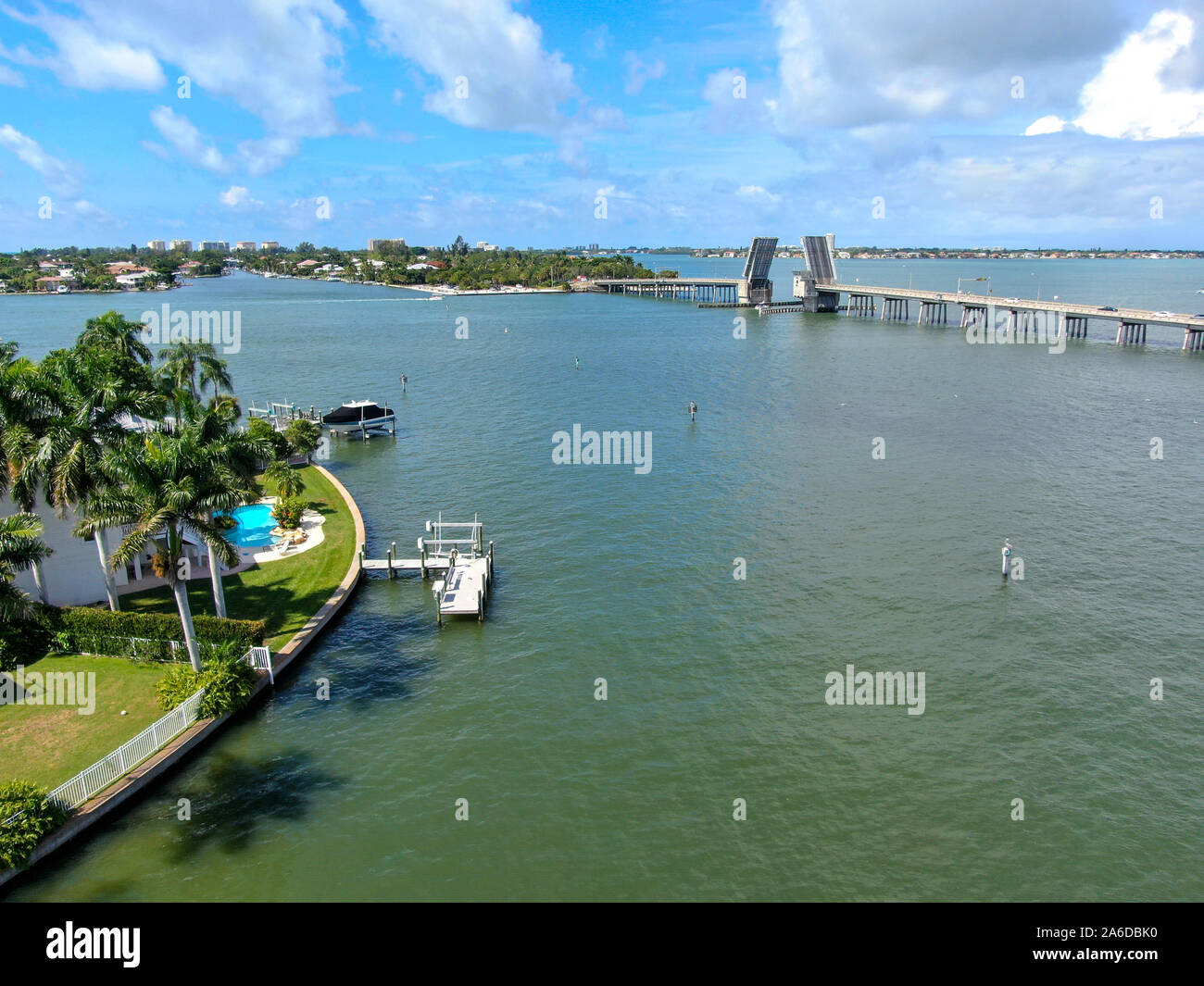Aerial view of open street bridge crossing ocean with small boat and ...