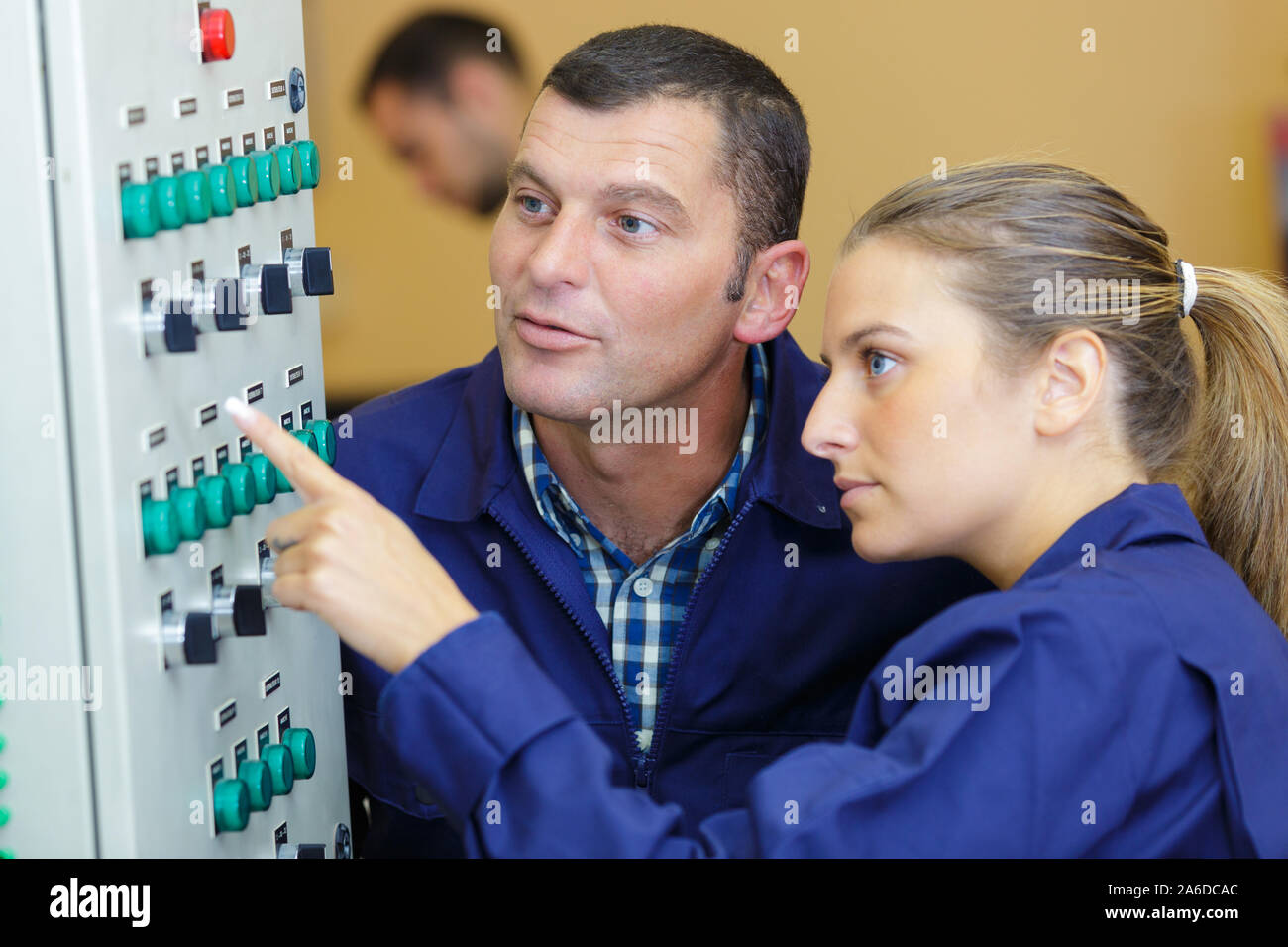 apprentice being shown electronic control panel in factory Stock Photo ...