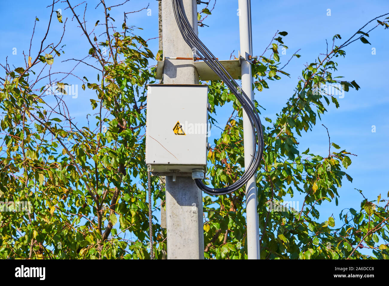 Locked rusty grey electric panel with hazard sign on the grey concrete ...