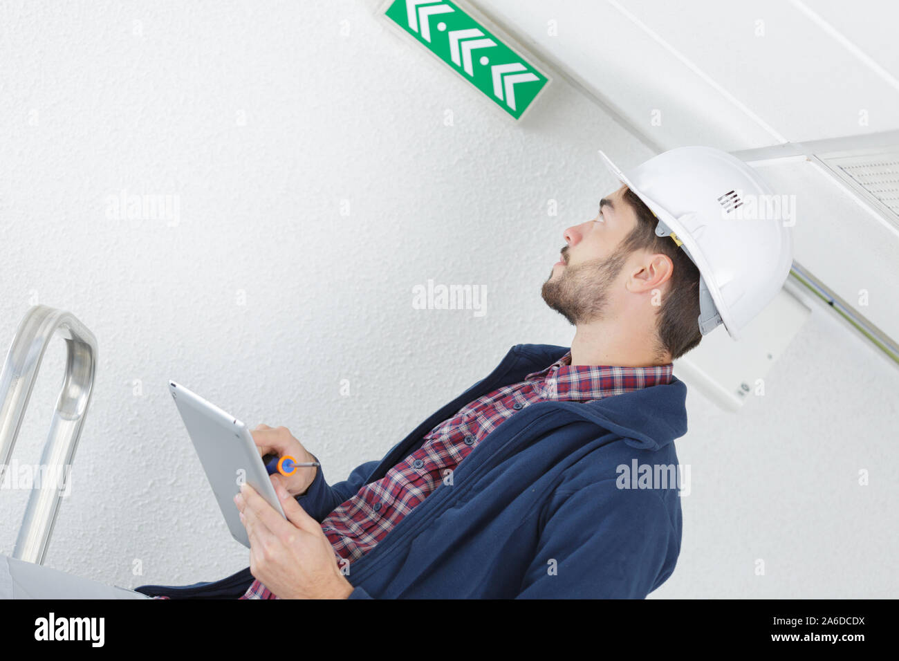 professional worker checking exit sign Stock Photo - Alamy