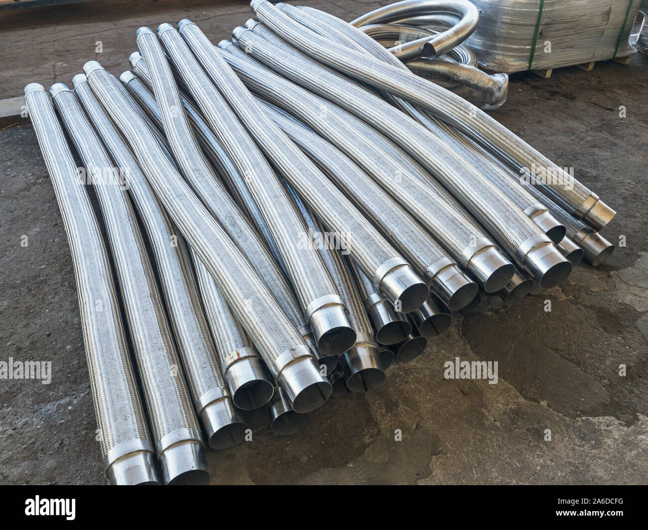 Long metal flexible compensator pipes on concerte floor. White metal ...
