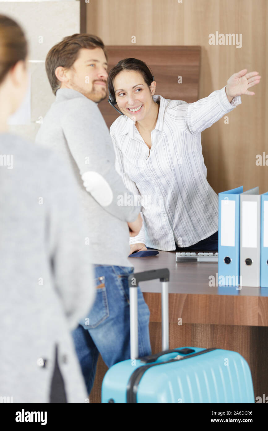 receptionist pointing guest towards his room Stock Photo - Alamy