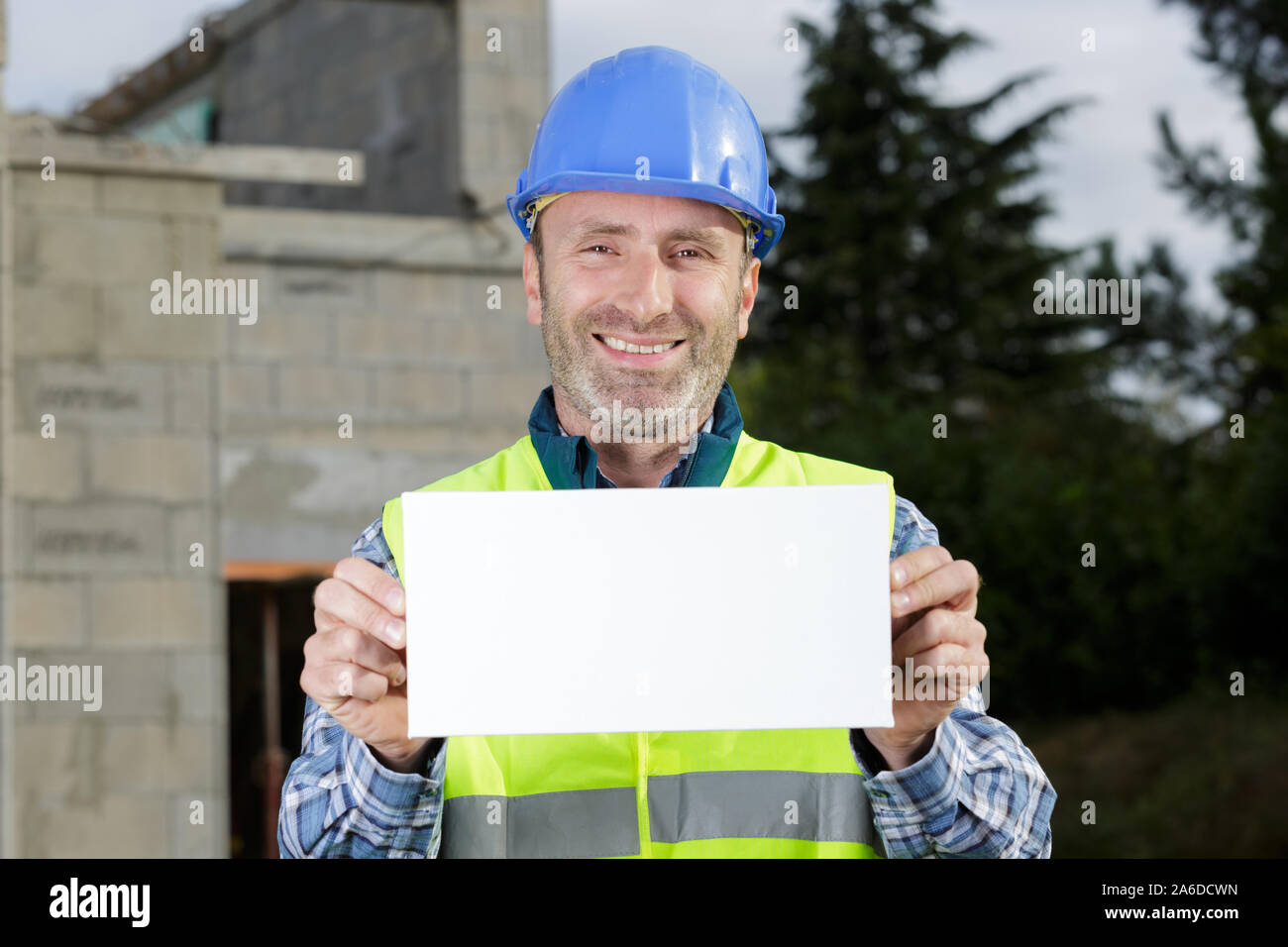 happy male engineer holding an advertisement blank banner Stock Photo ...