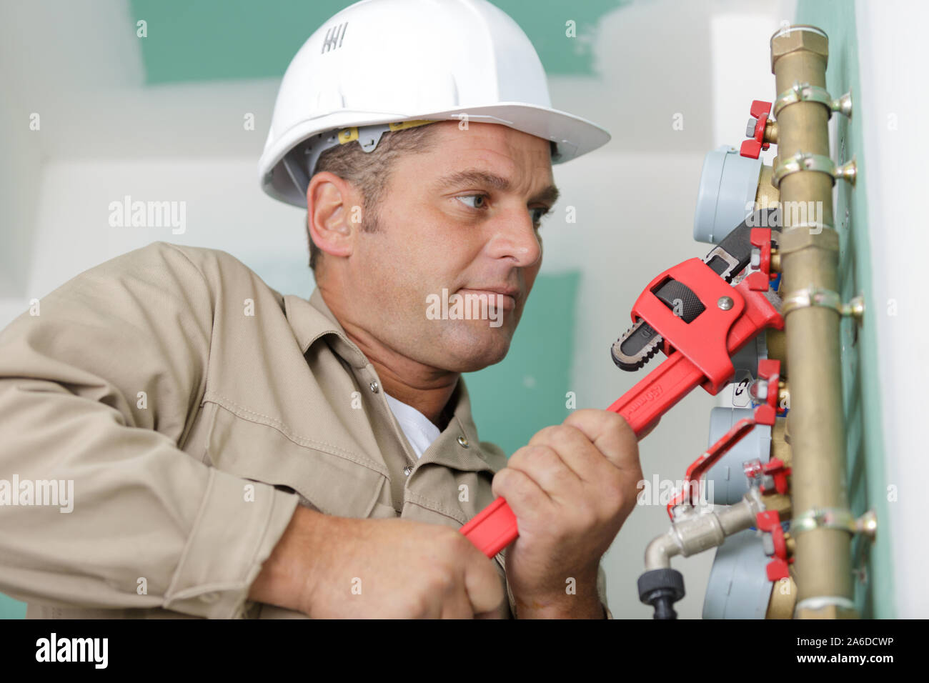 male plumber fixing water meter with adjustable wrench Stock Photo - Alamy