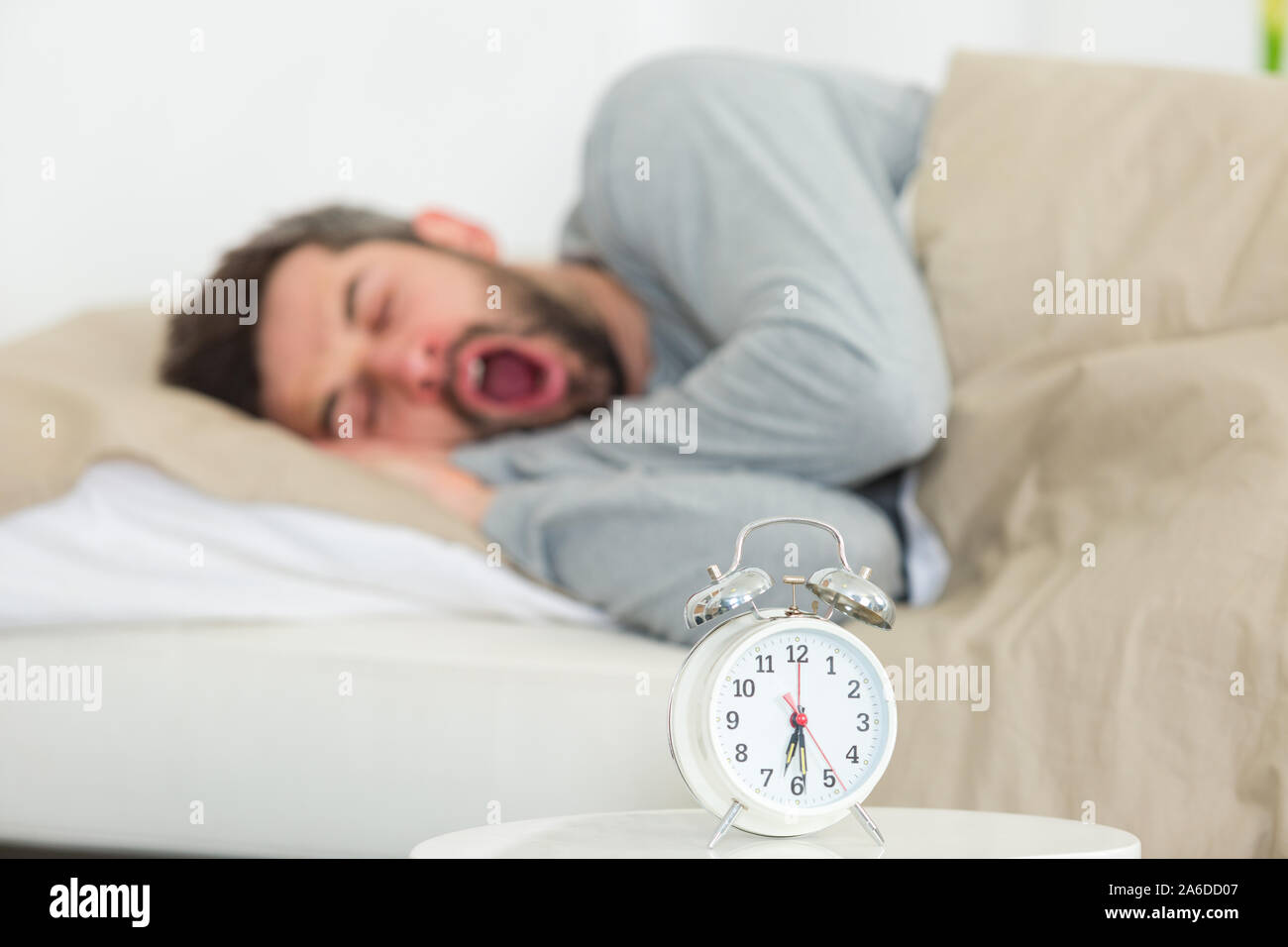 man waking up in the morning with an alarm clock Stock Photo - Alamy