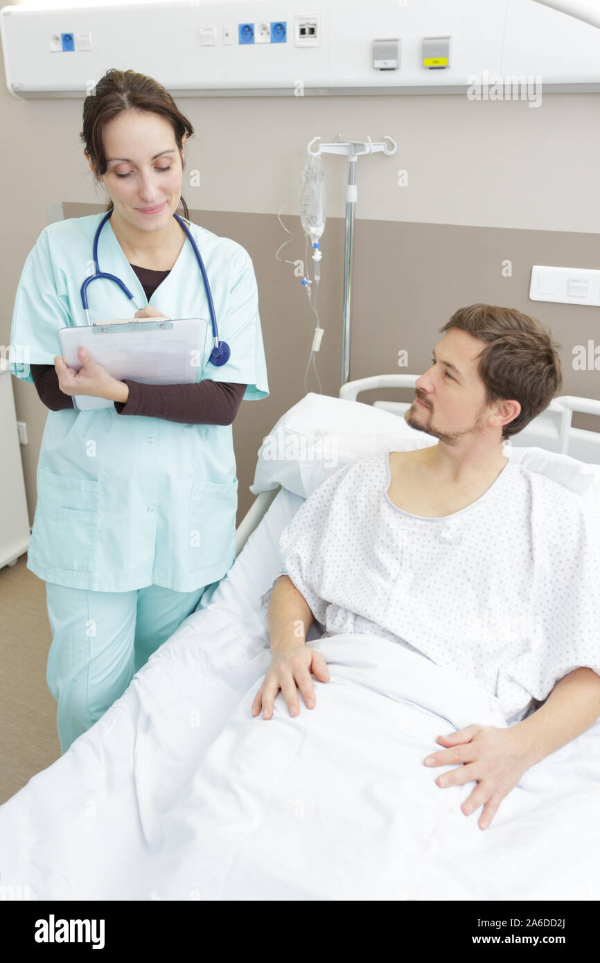 nurse recording patients information on clipboard Stock Photo - Alamy