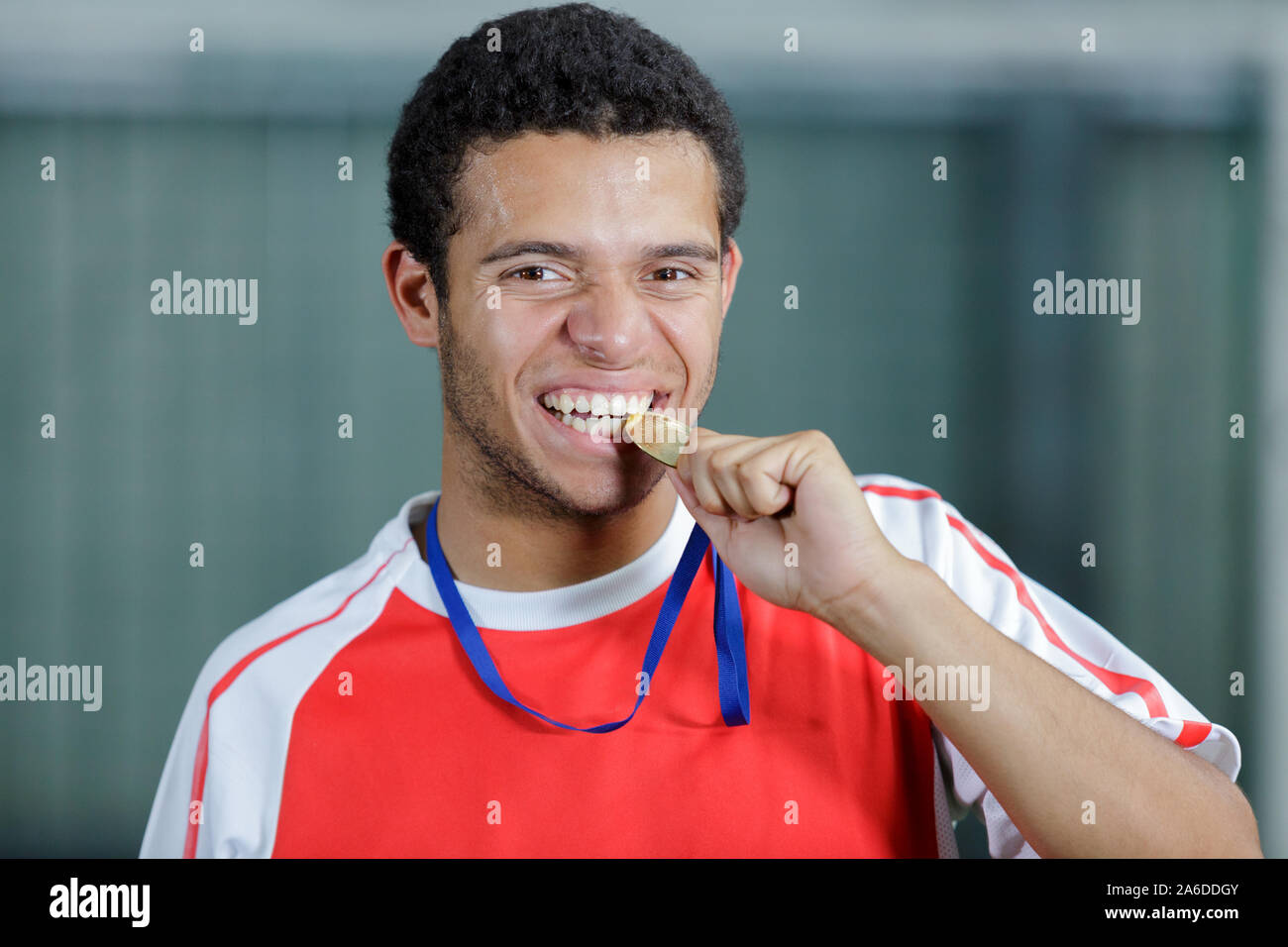portrait of man biting his medal Stock Photo - Alamy