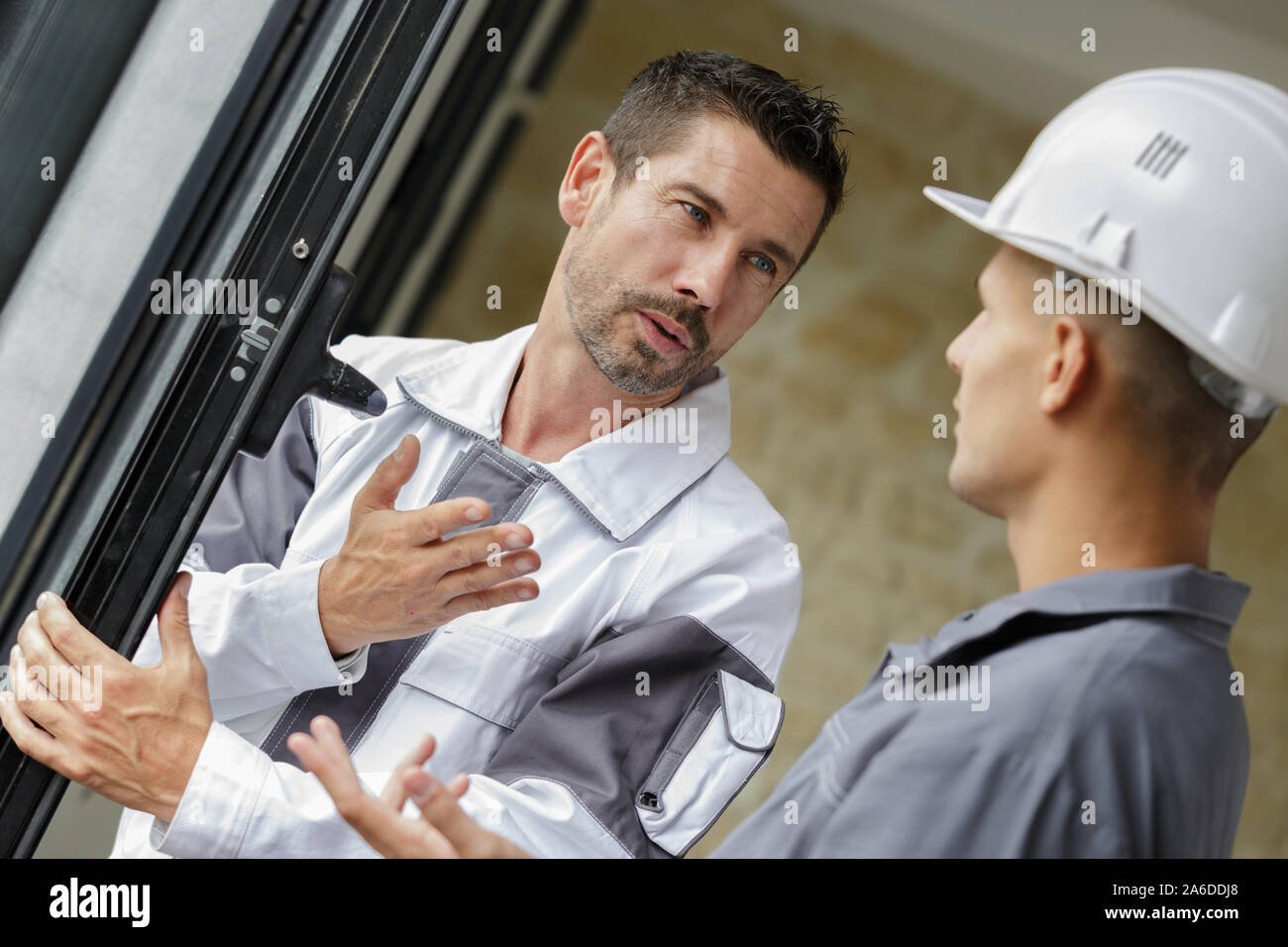 Double Glazing Installer In Conversation With Young Apprentice Stock