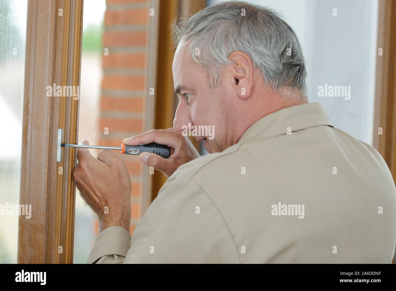 senior man fitting a window Stock Photo - Alamy