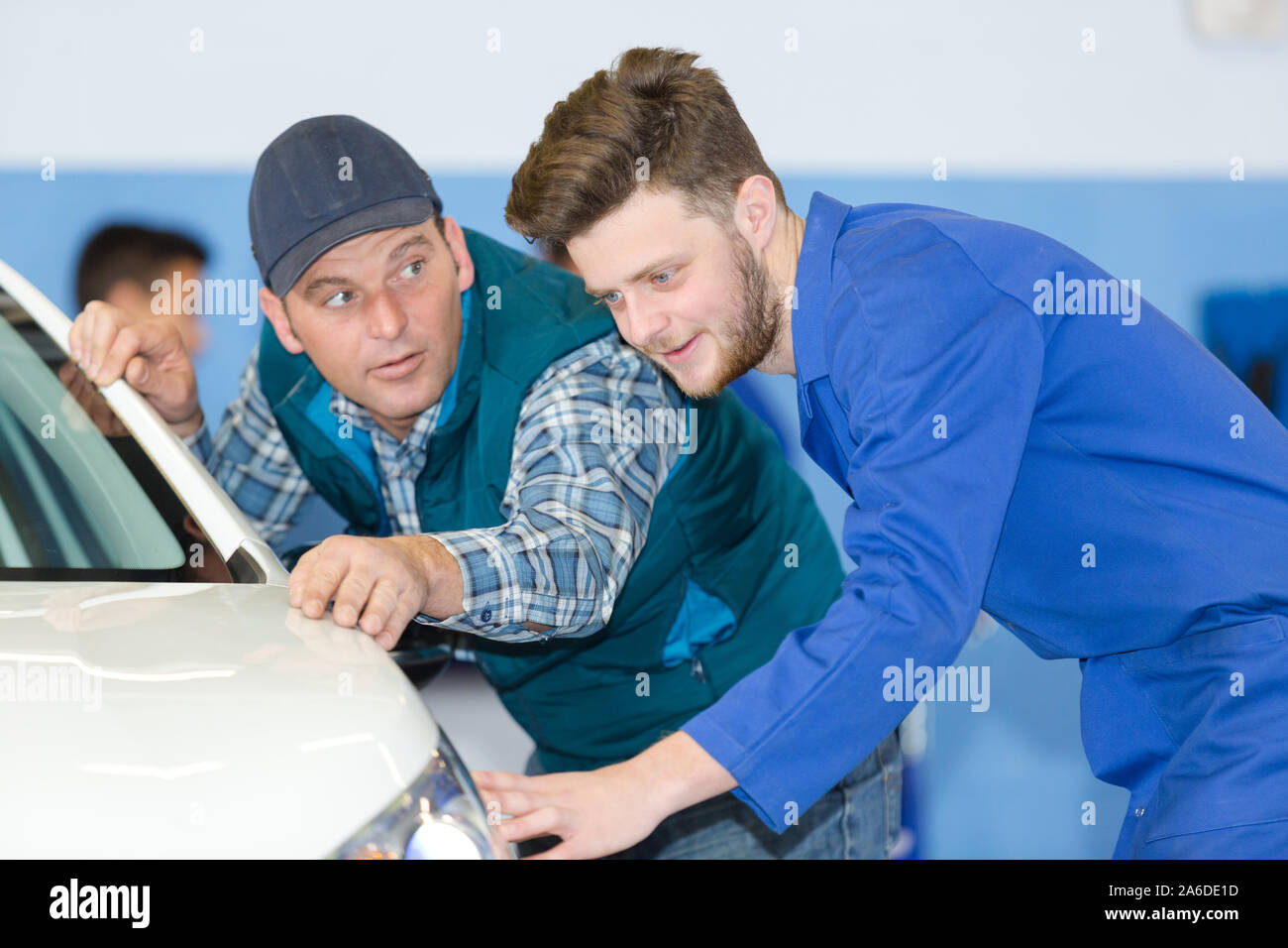 apprentice mechanic talking to teacher Stock Photo - Alamy