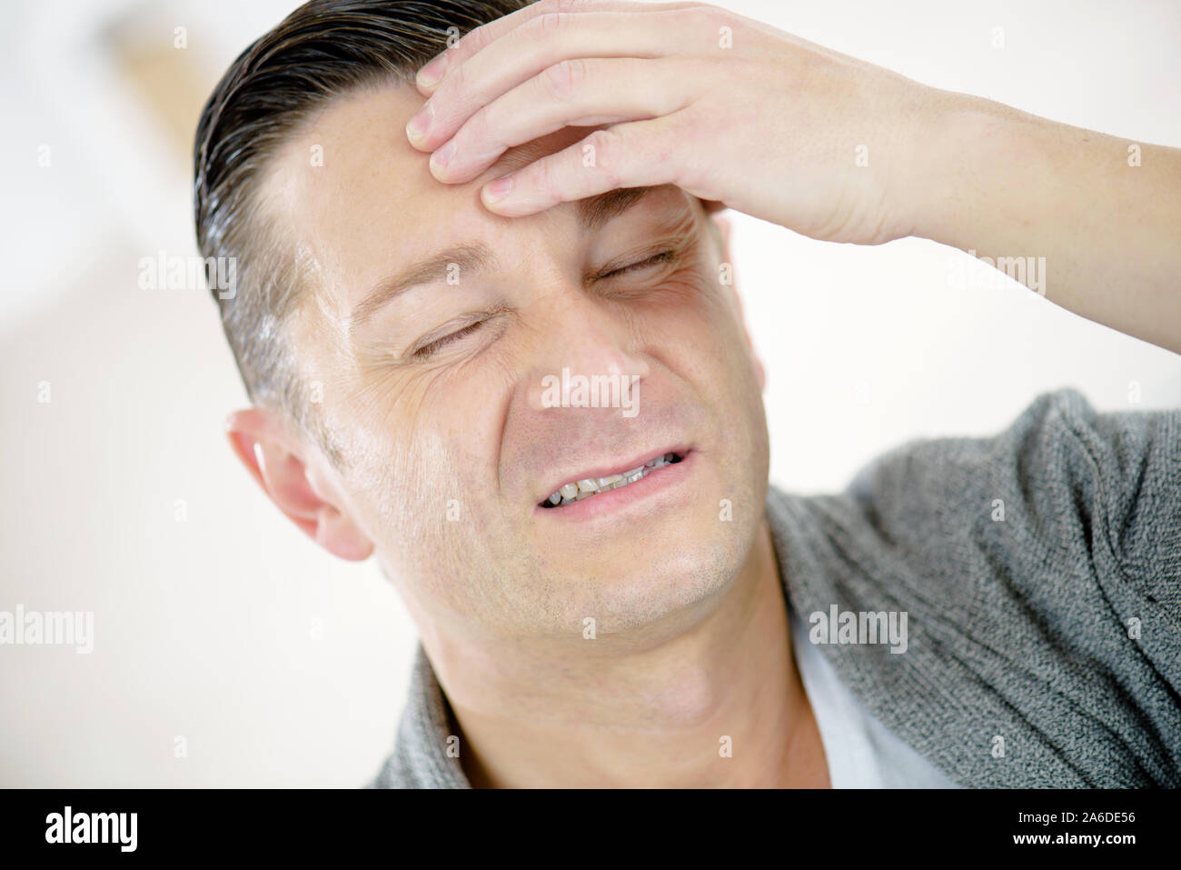 closeup of man grimacing and holding his head in pain Stock Photo - Alamy