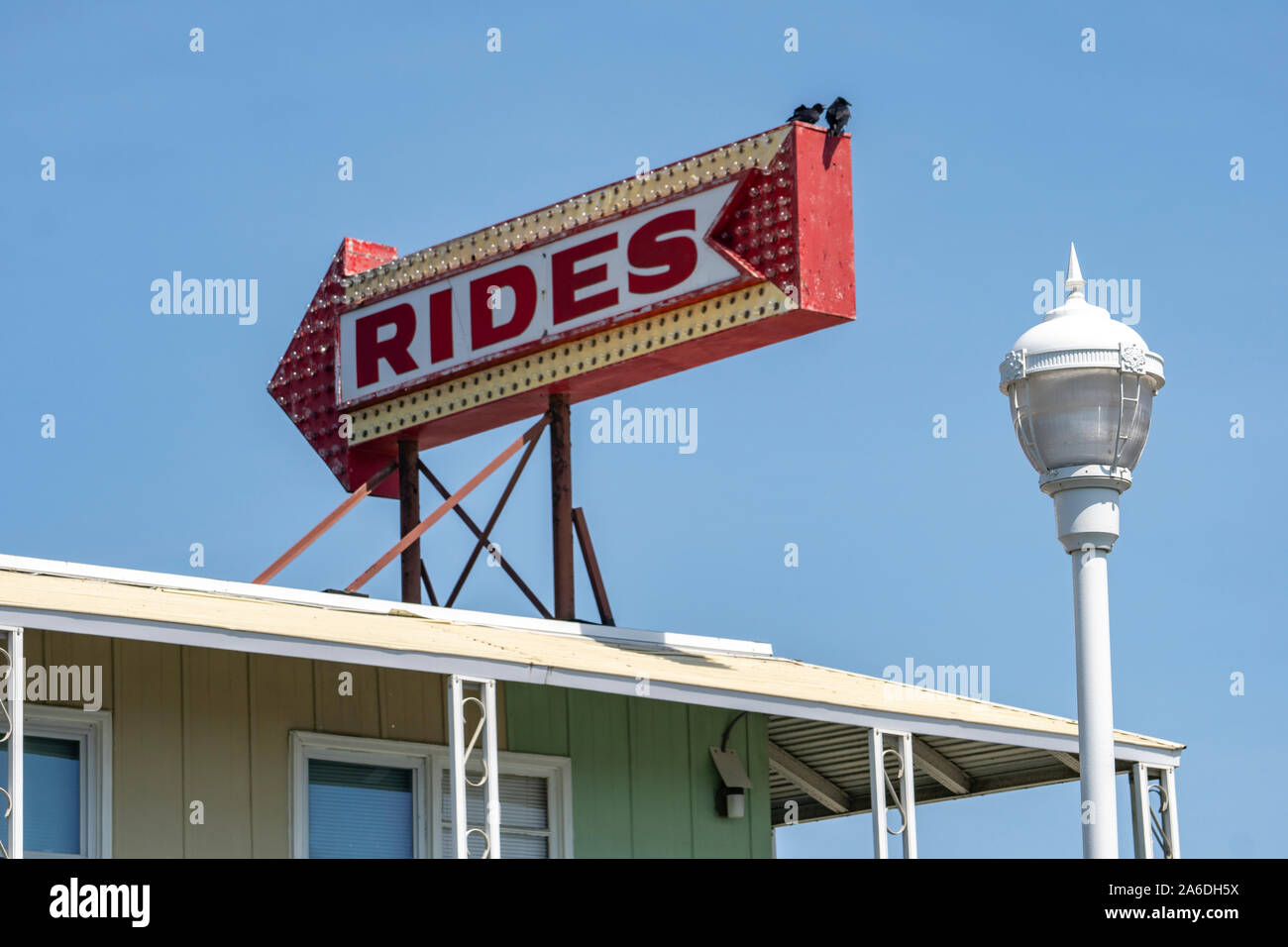 A red sign with arrow pointing at the boardwalk where carnival rides ...
