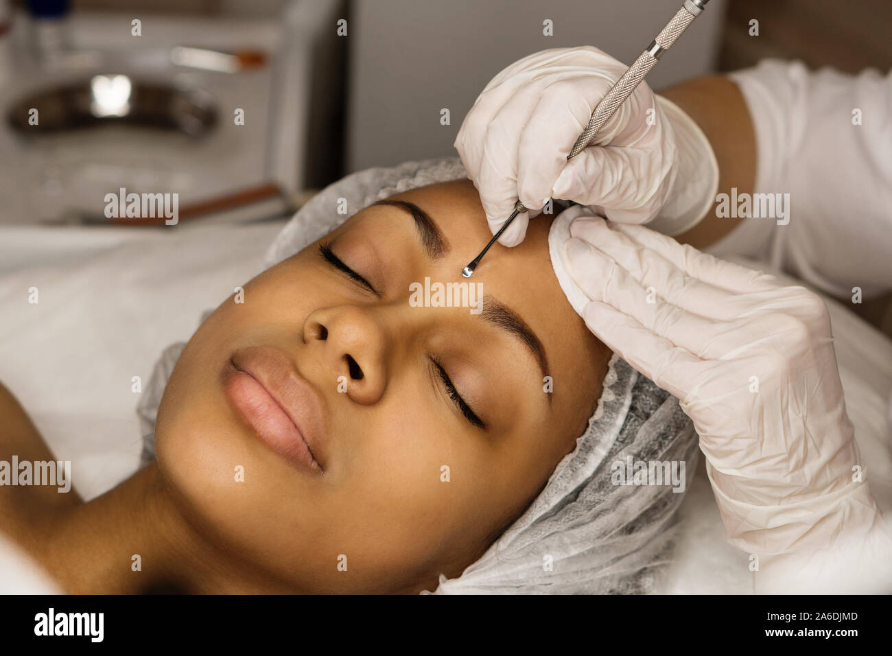 Procedure mechanical face cleaning in beauty salon. Afro american young ...