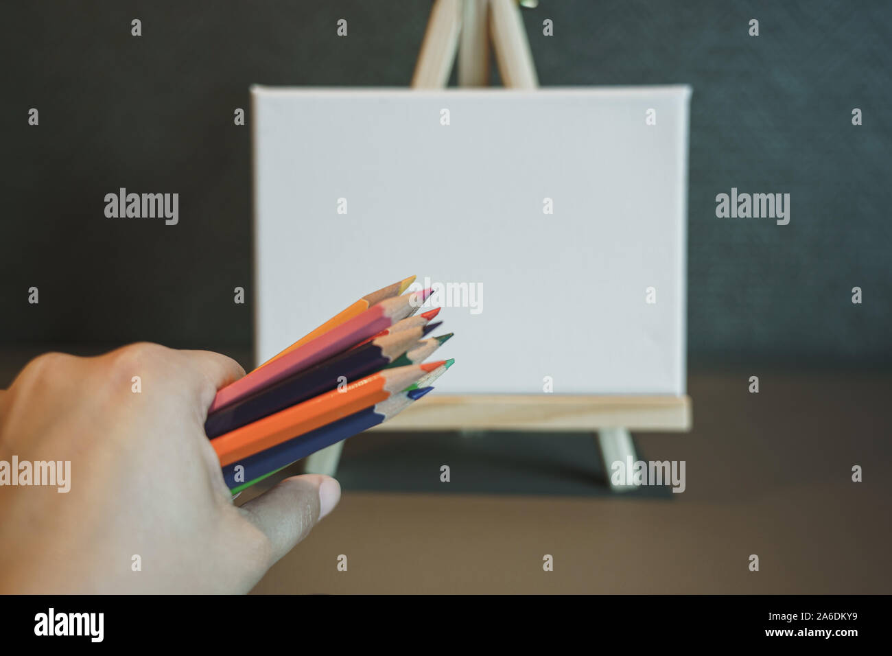 Hand with pencil on painting easel; vintage style Stock Photo - Alamy