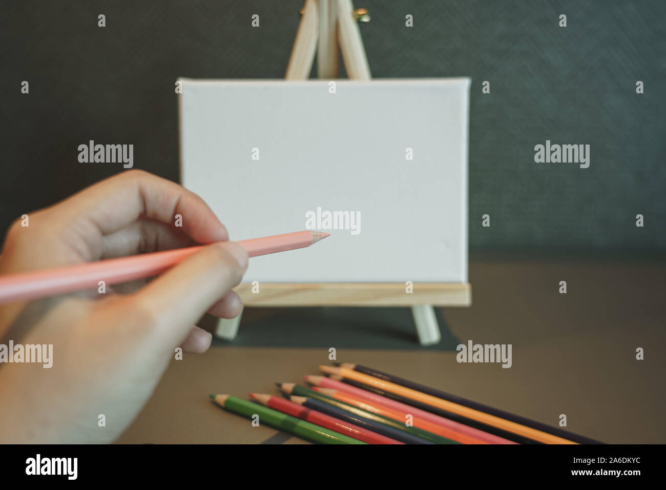 Hand with pencil on painting easel; vintage style Stock Photo - Alamy