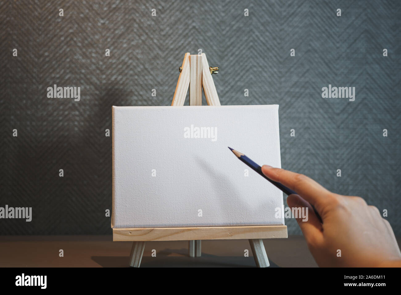 Hand with pencil on painting easel; vintage style Stock Photo - Alamy