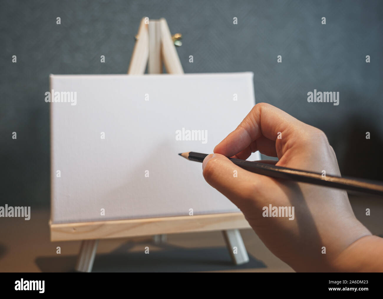 Hand with pencil on painting easel; vintage style Stock Photo - Alamy